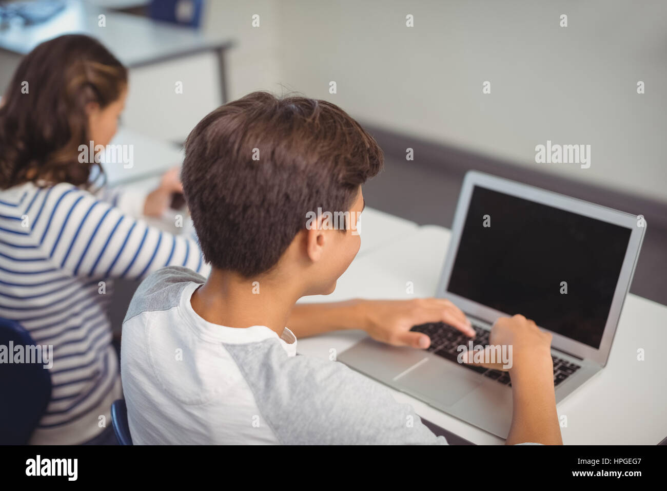 Student using laptop in classroom at school Stock Photo - Alamy