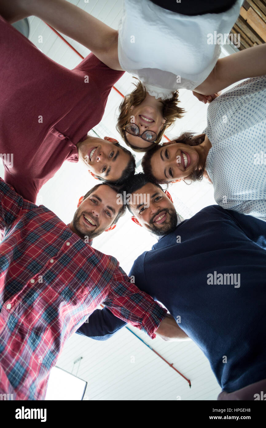 Team of businesspeople forming huddle in office Stock Photo - Alamy
