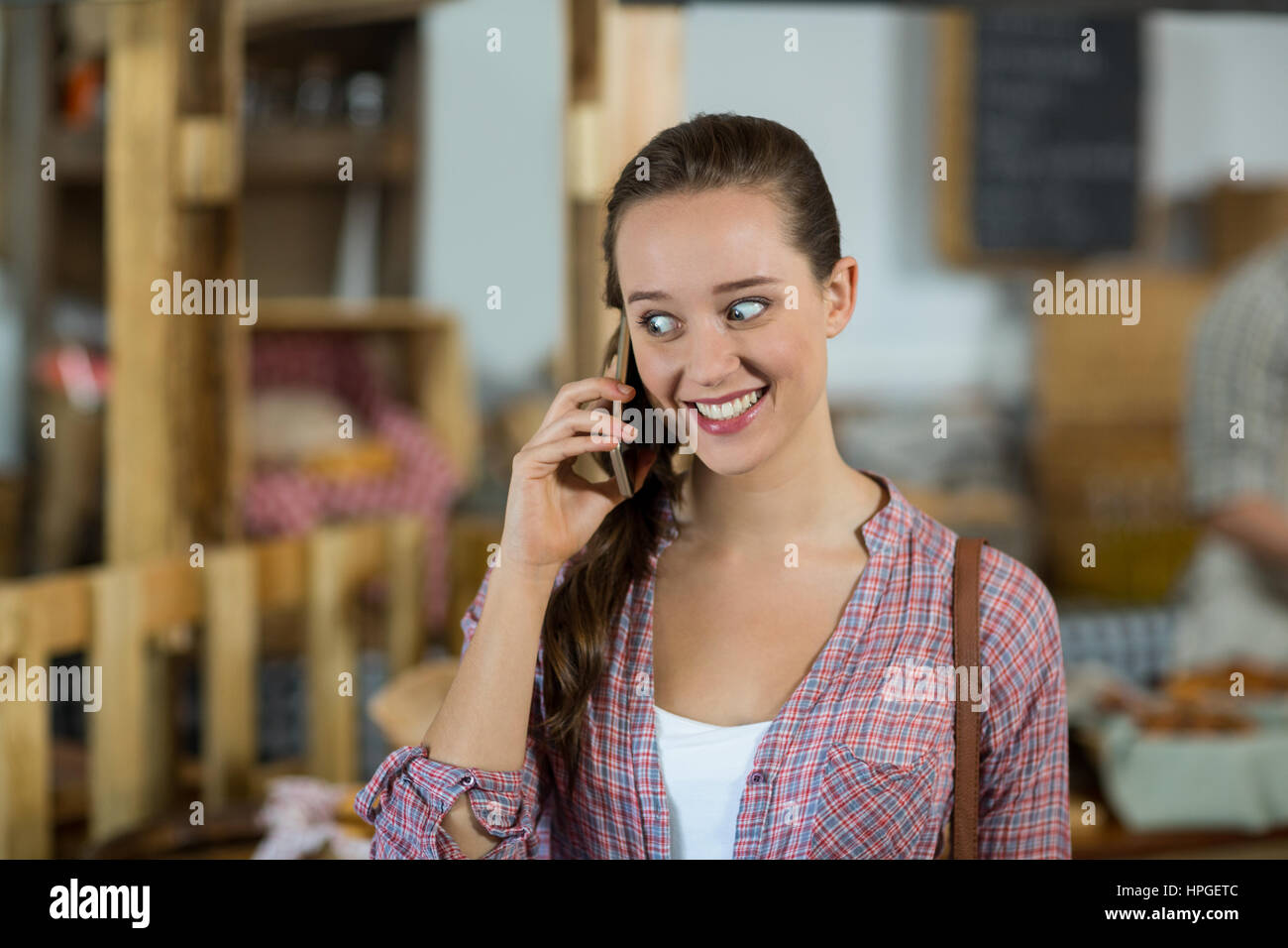 Female customer talking on the phone in grocery shop Stock Photo - Alamy