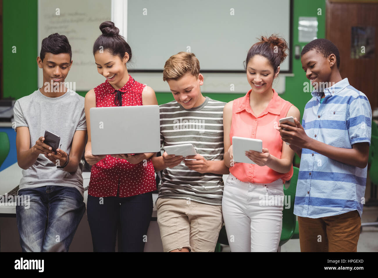 Students using laptop, mobile phone, digital tablet in classroom Stock ...