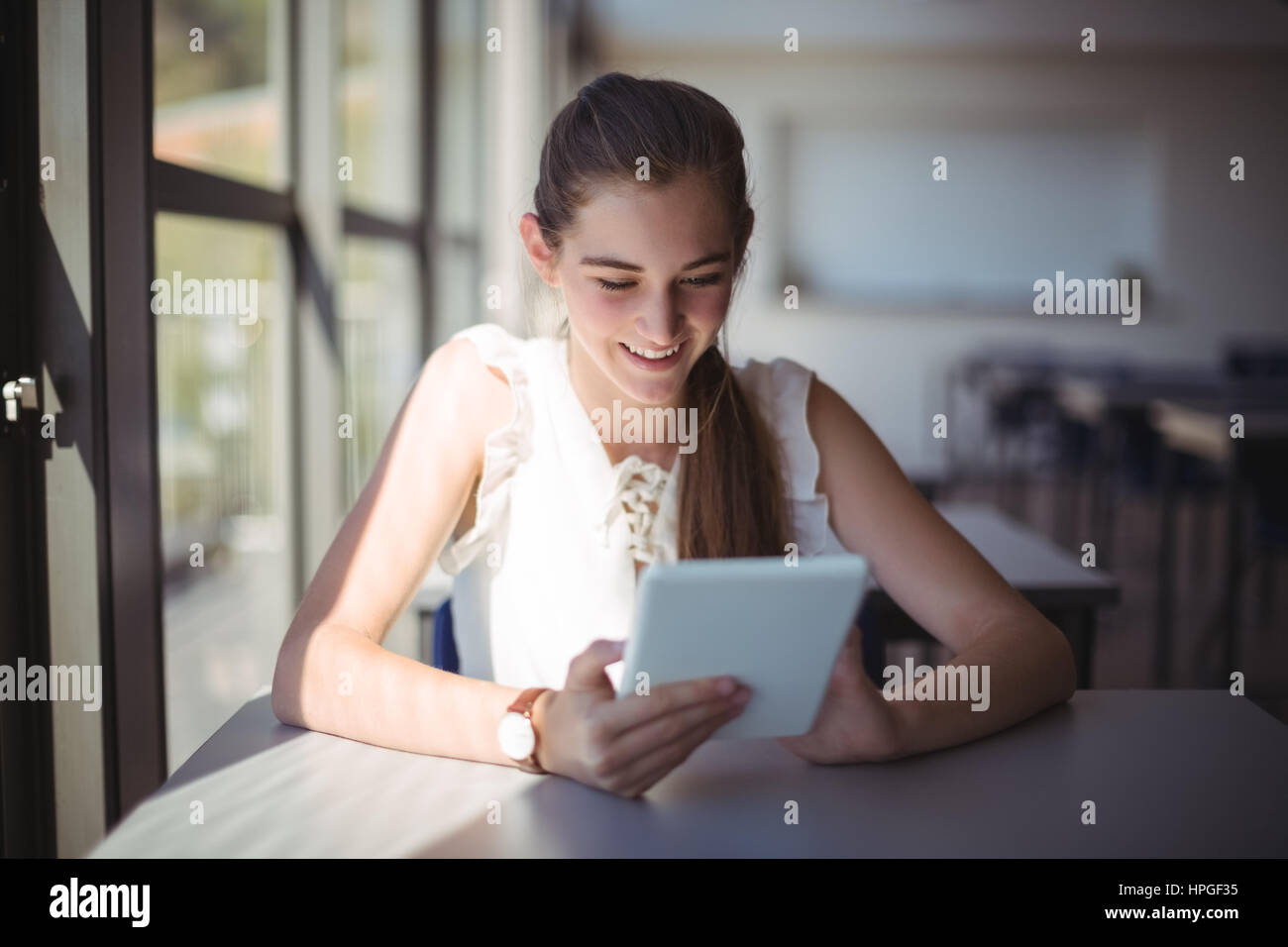Schoolgirl using digital tablet in classroom at school Stock Photo - Alamy