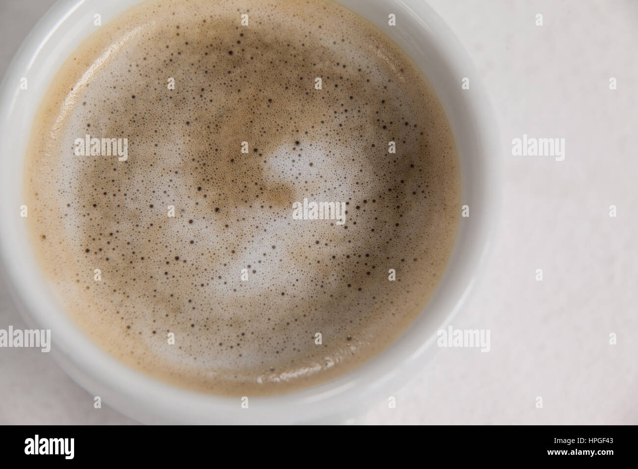 Close-up of white coffee cup with creamy froth on white background ...