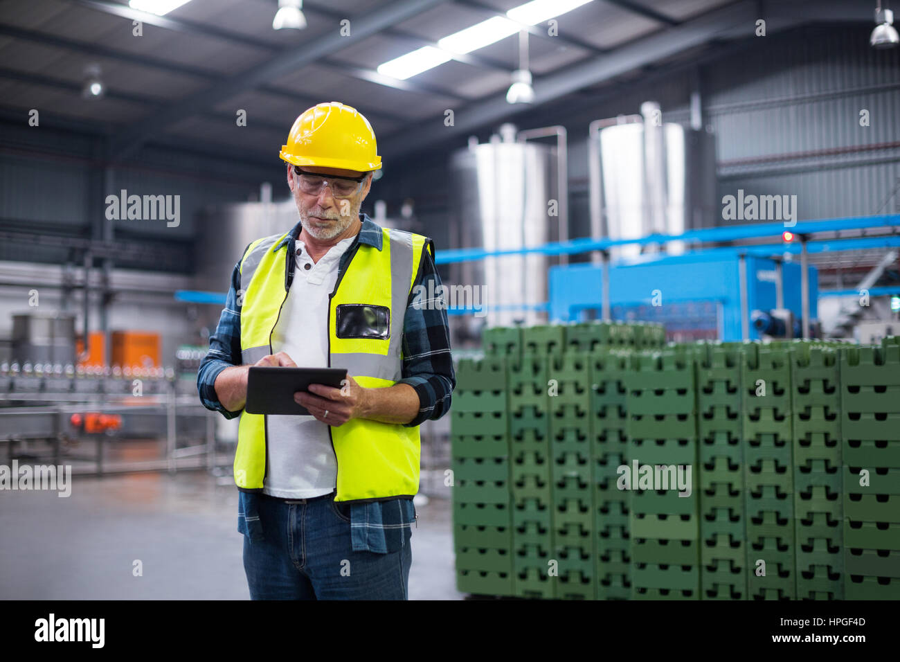 Male factory worker maintaining record on clipboard in drinks ...