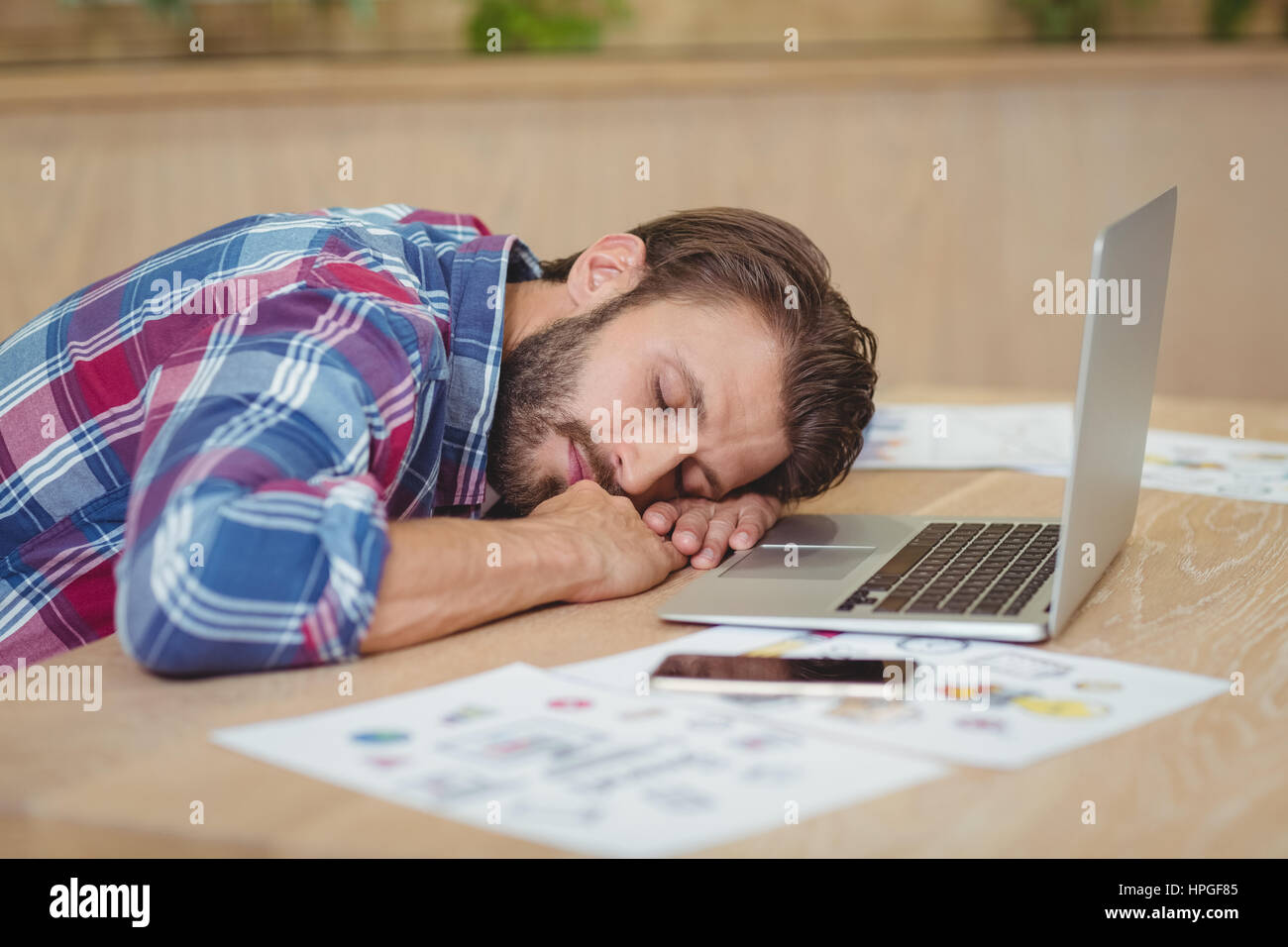 Tired business executive sleeping on desk while working in office Stock ...