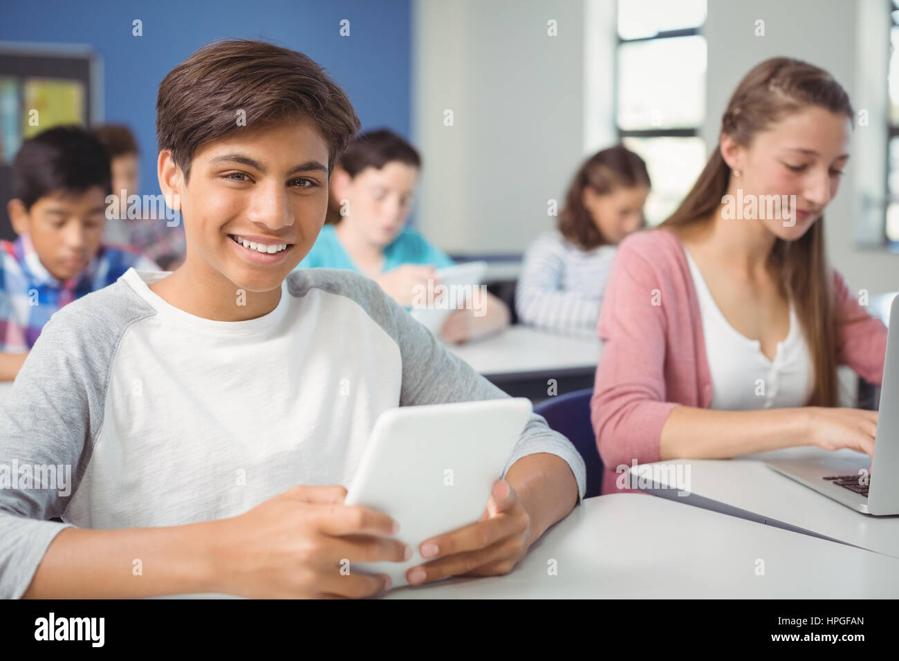 Students using digital tablet and laptop in classroom at school Stock ...
