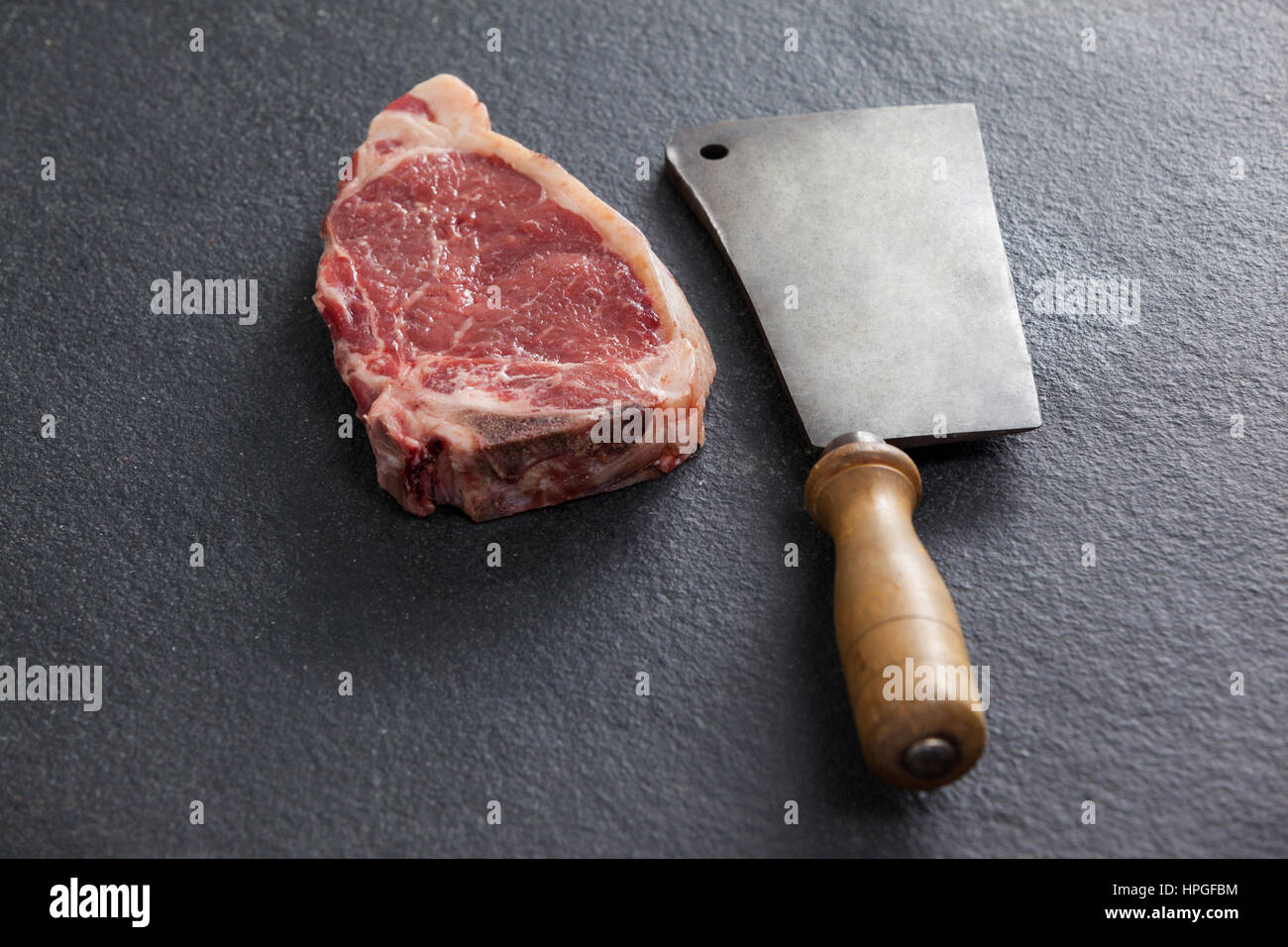 Close-up of sirloin chop and cleaver against black background Stock ...