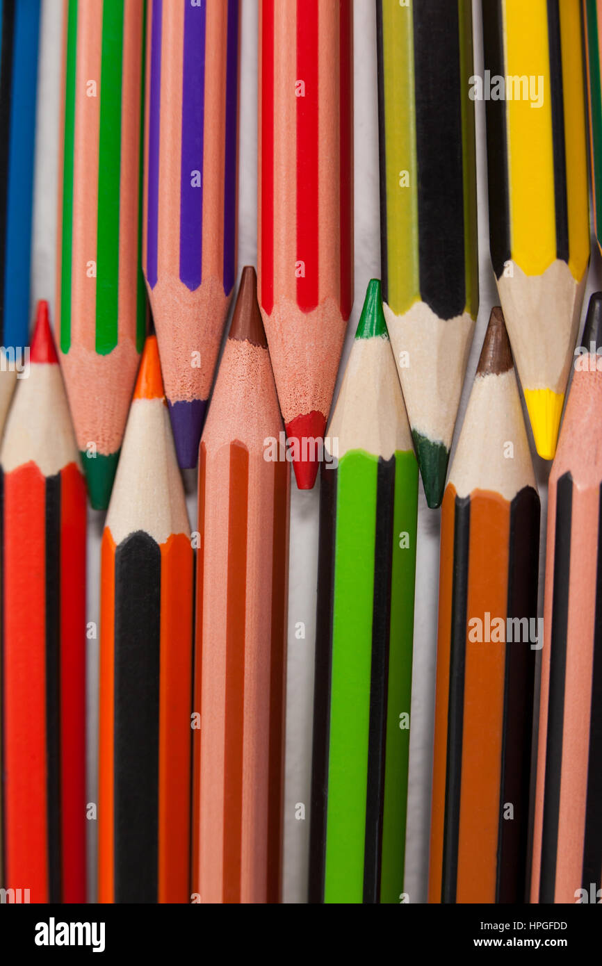 Close-up of colored pencils arranged in interlock pattern on white ...