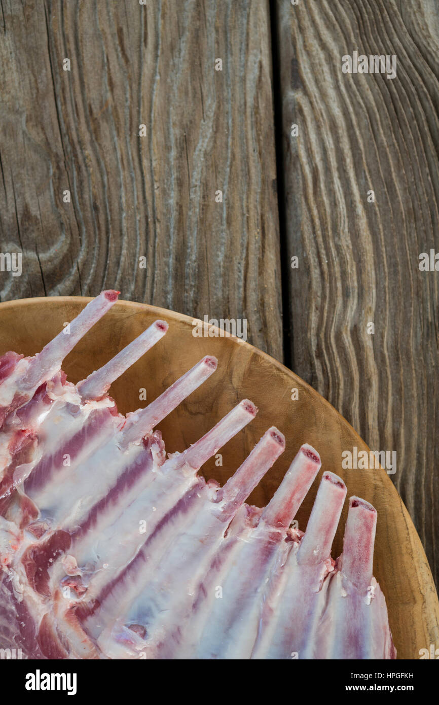 Close-up of beef ribs rack on wooden tray against wooden background ...