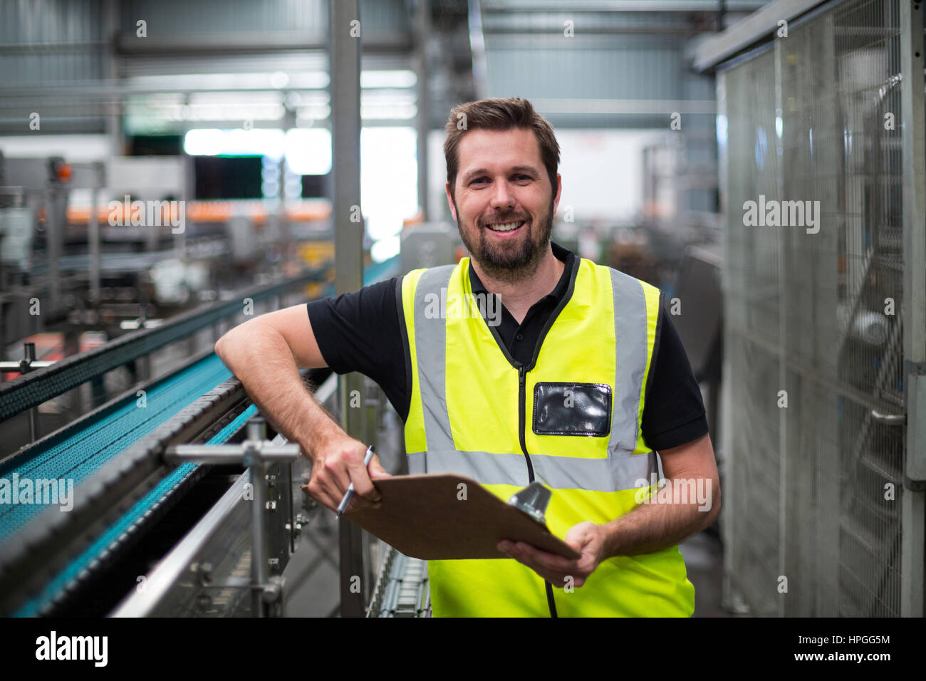Portrait of factory worker standing with clipboard in factory Stock ...