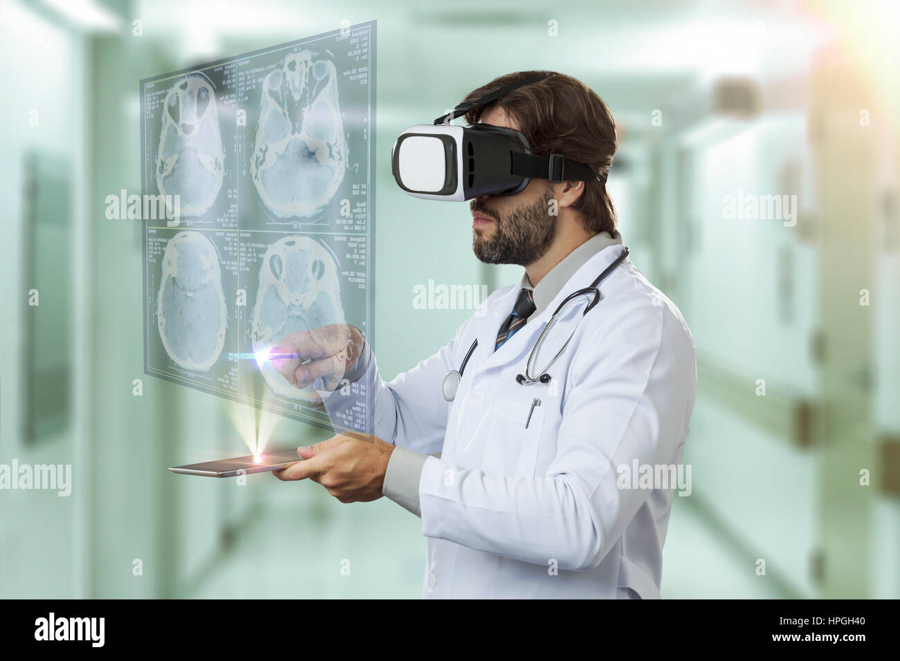 Male doctor at a hospital, looking at a virtual screen coming out of a ...