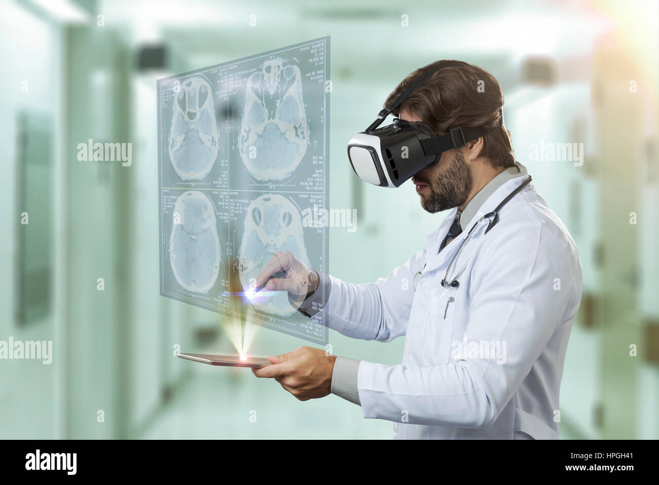 Male doctor at a hospital, looking at a virtual screen coming out of a ...