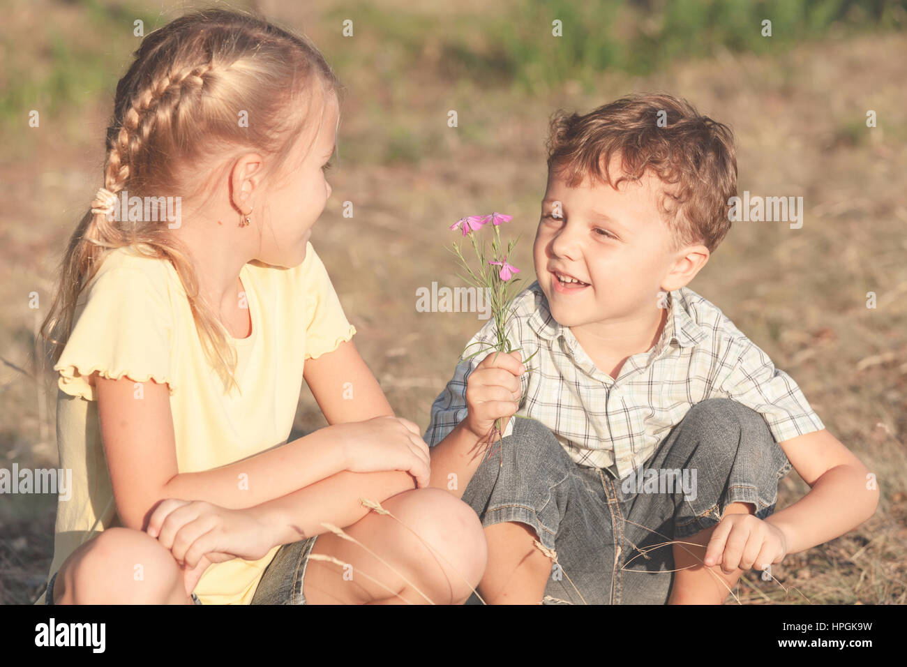 Two happy children playing near the tree at the day time Stock Photo ...