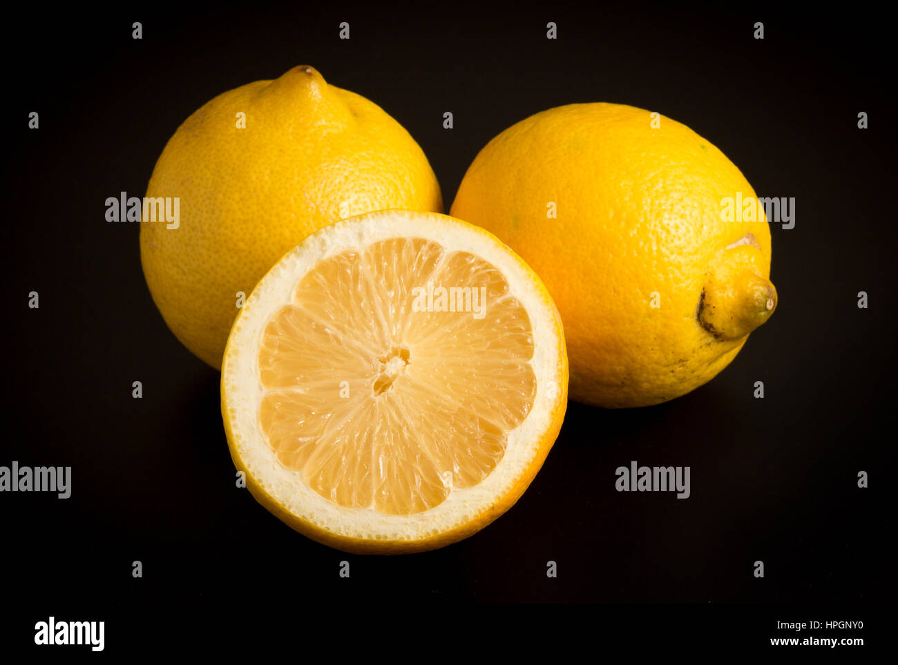 Studio shot of sliced and whole lemons isolated on black background ...