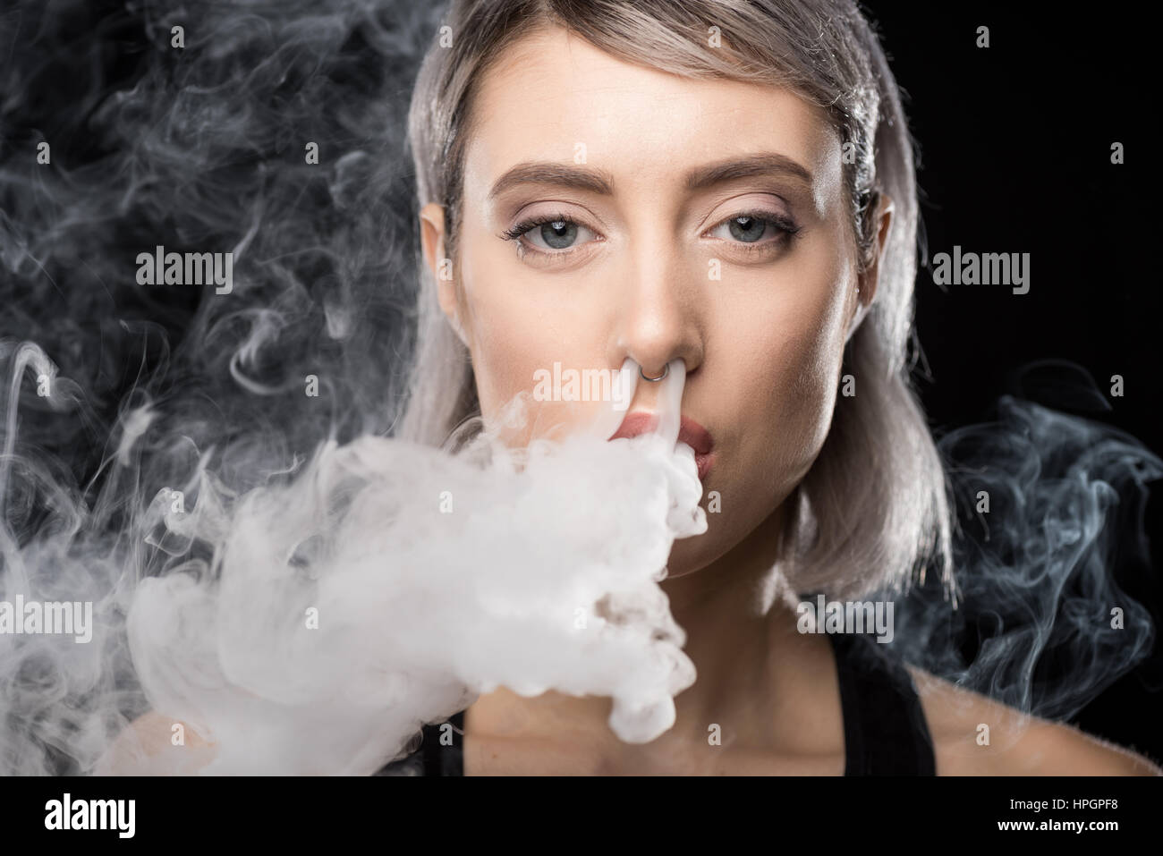 woman vaping and blowing smoke of electronic cigarette from nose Stock ...