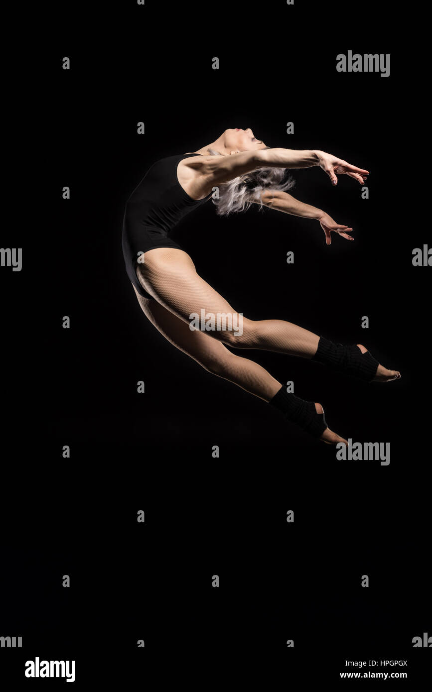 side view of jumping woman in bodysuit Stock Photo - Alamy
