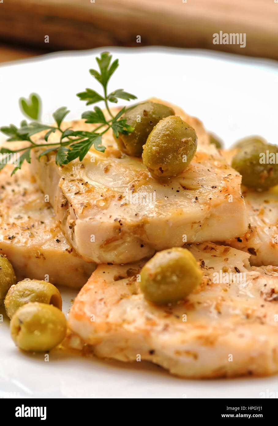 Cod fish with green olives Stock Photo - Alamy