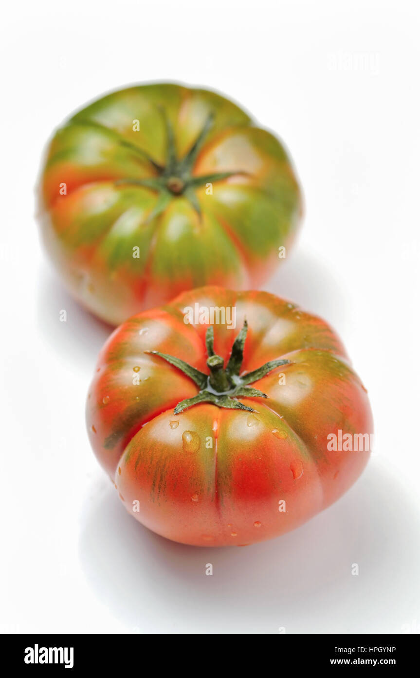Ripe red heirloom tomatoes isolated Stock Photo - Alamy