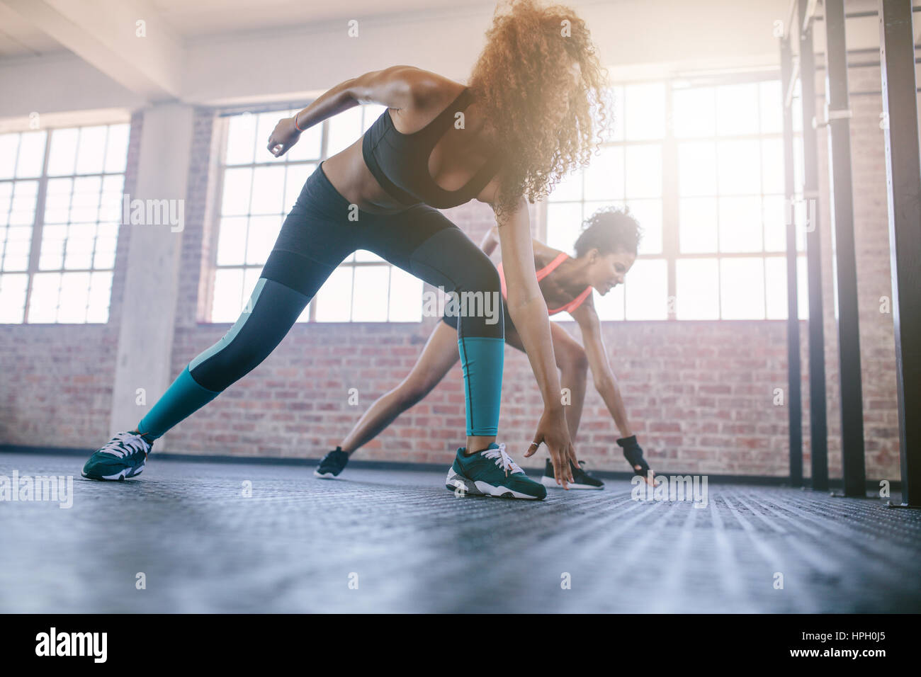 Shot of young females running in the gym. Women doing fitness workout ...