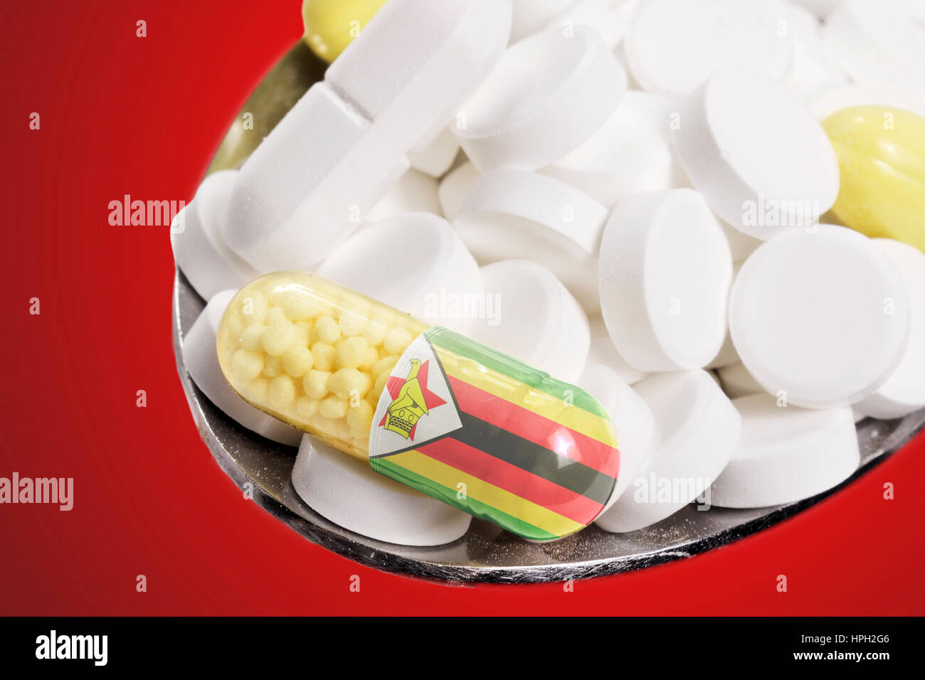 The national flag of Zimbabwe on a capsule and pills on a spoon.(series ...