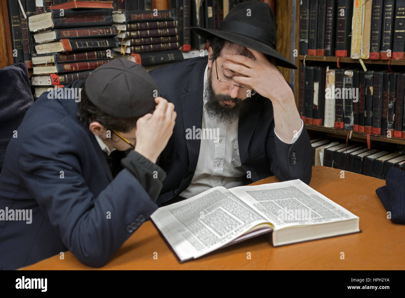 Two orthodox Jewish young men study Talmud together in a synagogue in ...