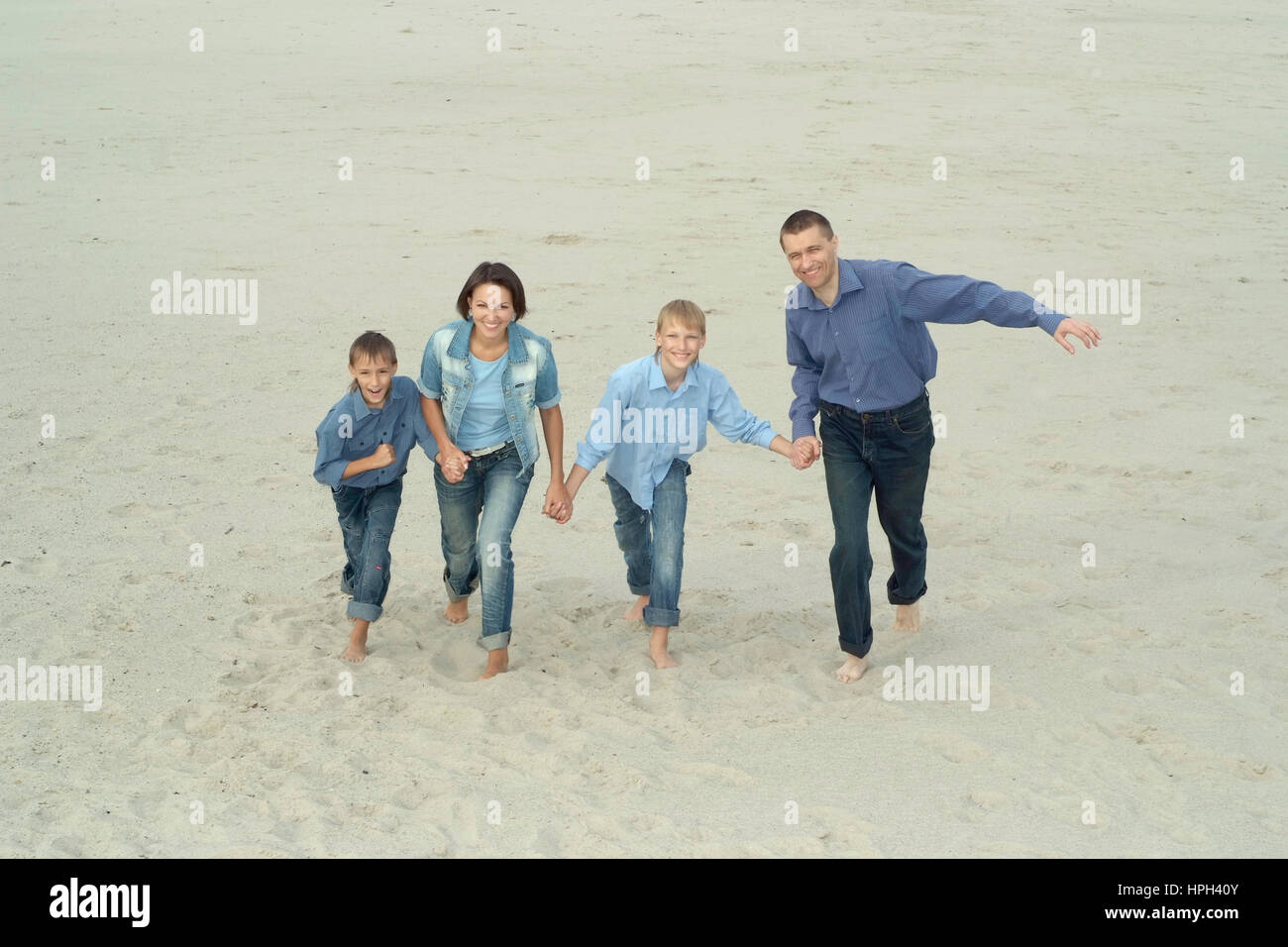 Family fun running barefoot in the sand Stock Photo - Alamy