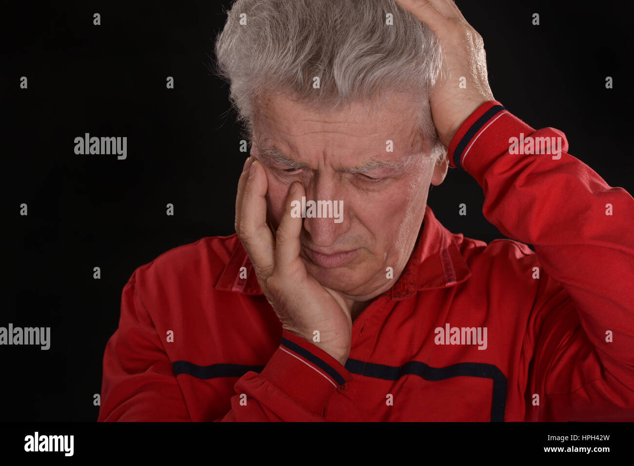 sad mature man in red on a black background Stock Photo - Alamy