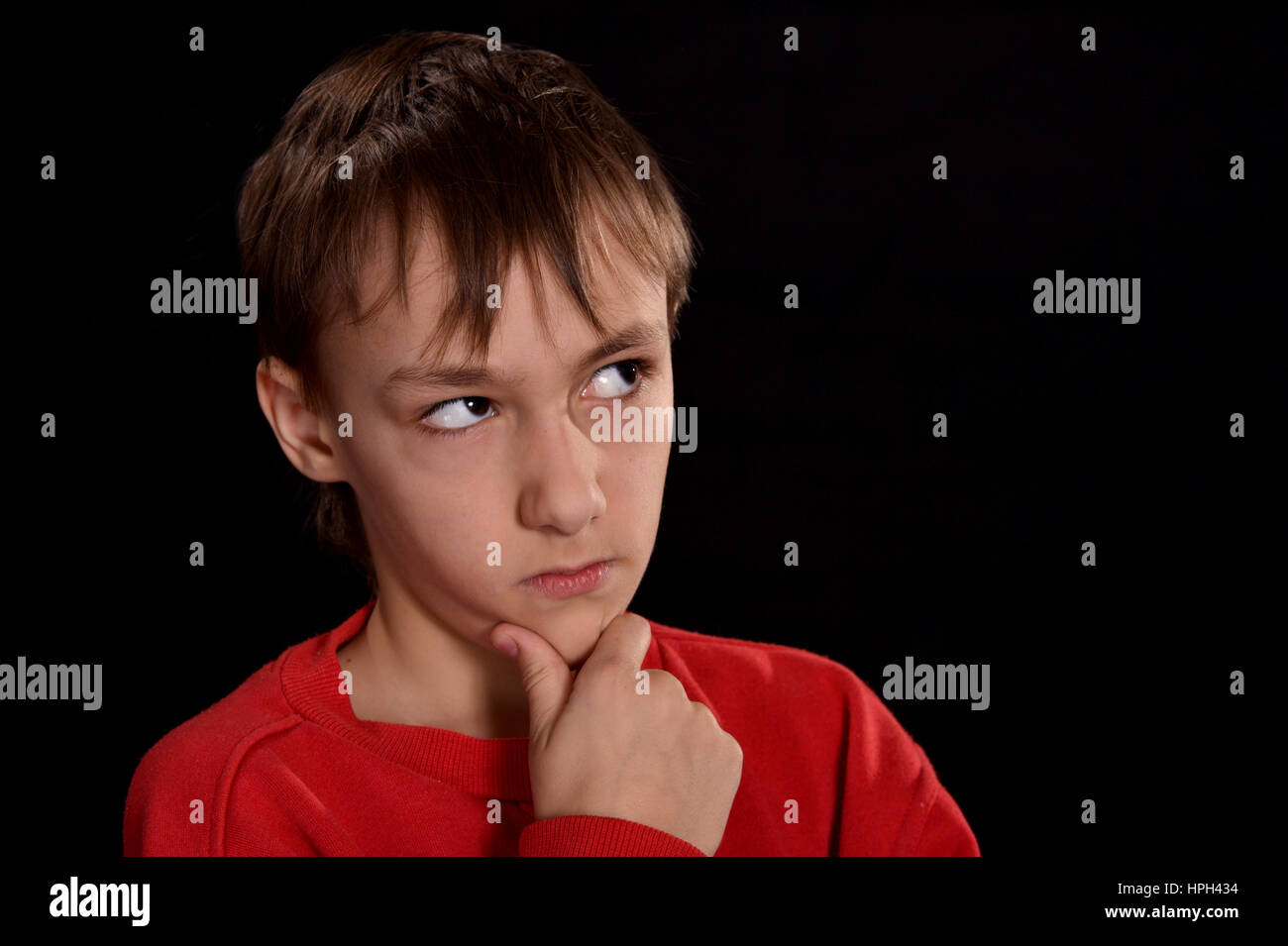 sad young guy in red on a black background Stock Photo - Alamy