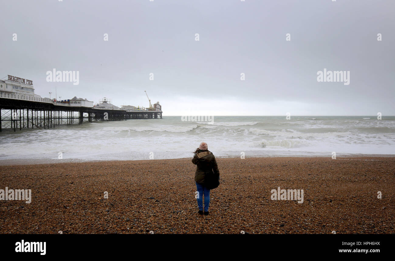 A woman watches the sea on the beach in Brighton, East Sussex, as the ...