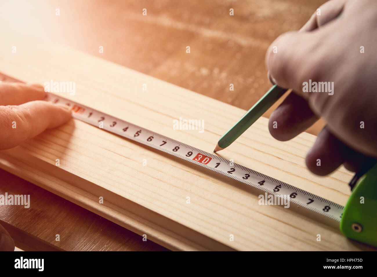 Carpenter measuring wooden board with setsquare and tape-measure Stock ...