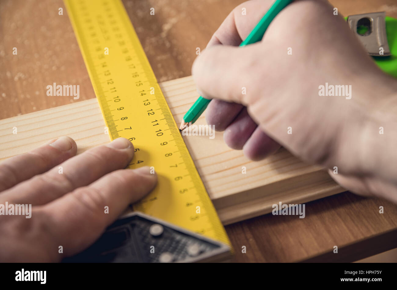 Carpenter measuring wooden board with setsquare and tape-measure Stock ...