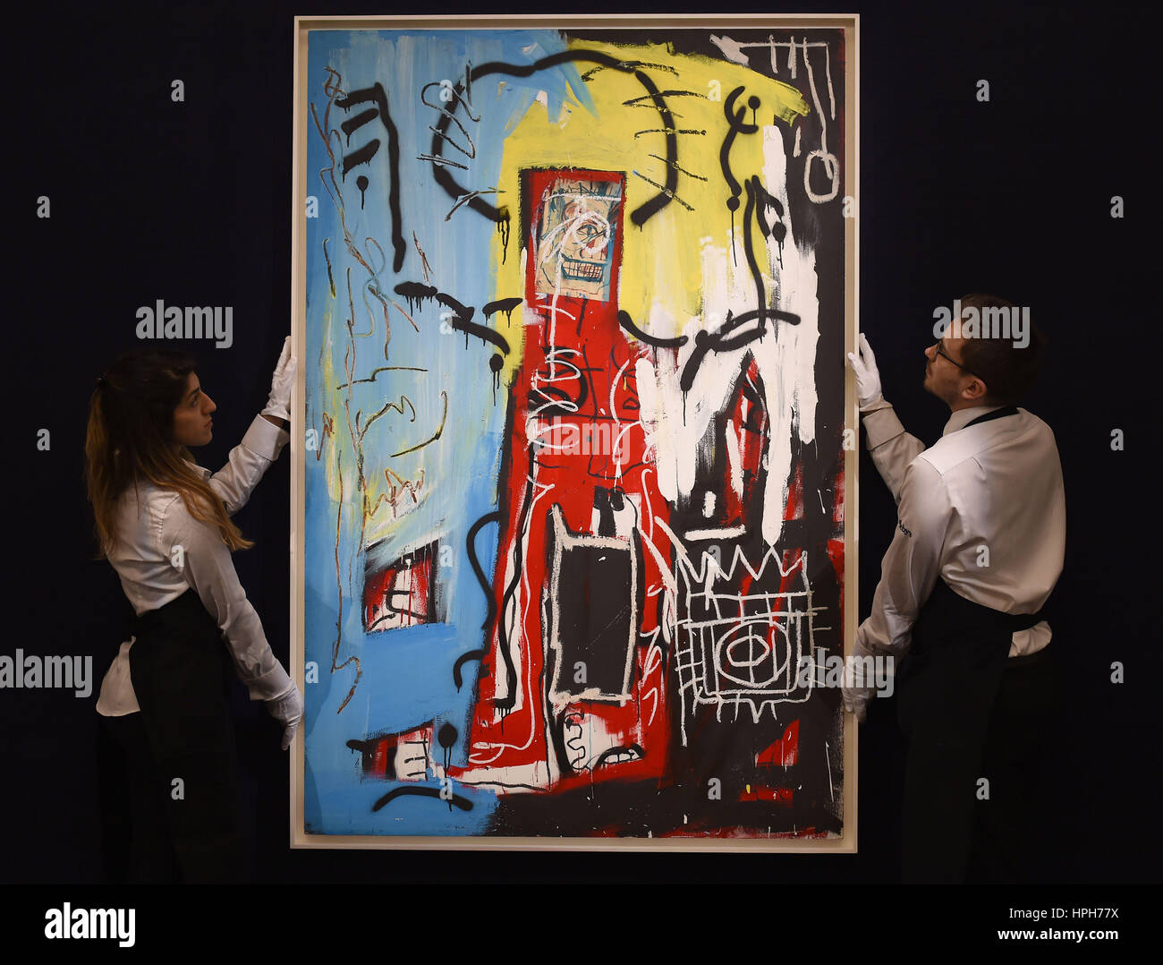 Sotheby's employees adjust Untitled (One Eyed Man or Xerox Face ...