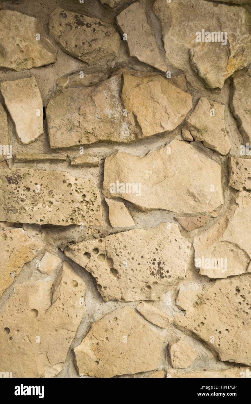 Rugged old limestone wall that is uneven, rustic and filled with cement ...