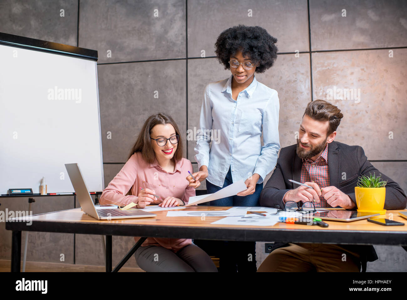 Coworkers working together indoors Stock Photo - Alamy