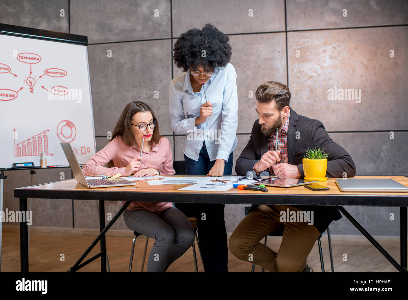 Coworkers working together indoors Stock Photo - Alamy