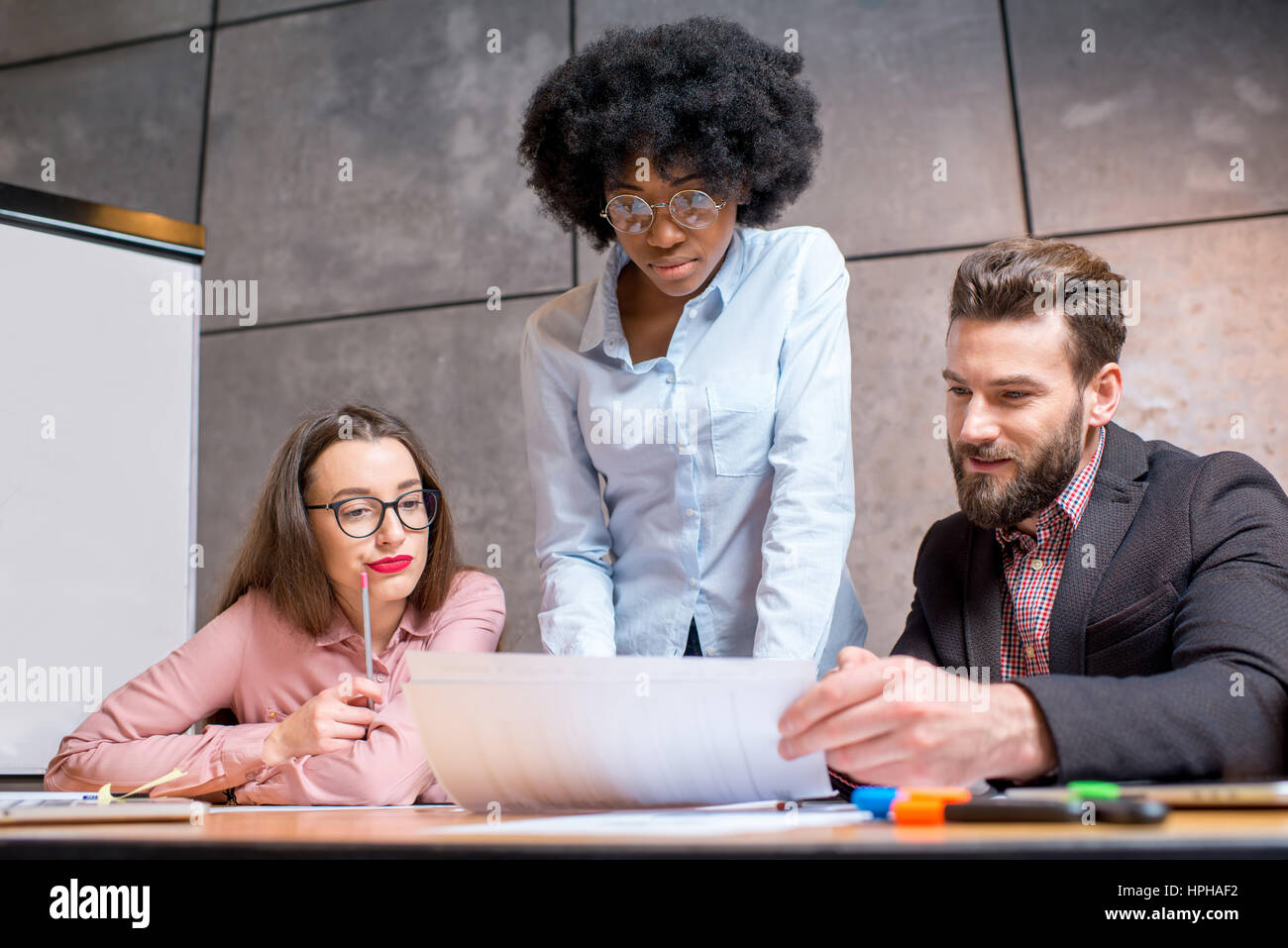 Coworkers working together indoors Stock Photo - Alamy