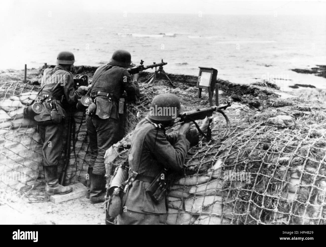 The Nazi propaganda image shows German Wehrmacht soldiers at machine ...