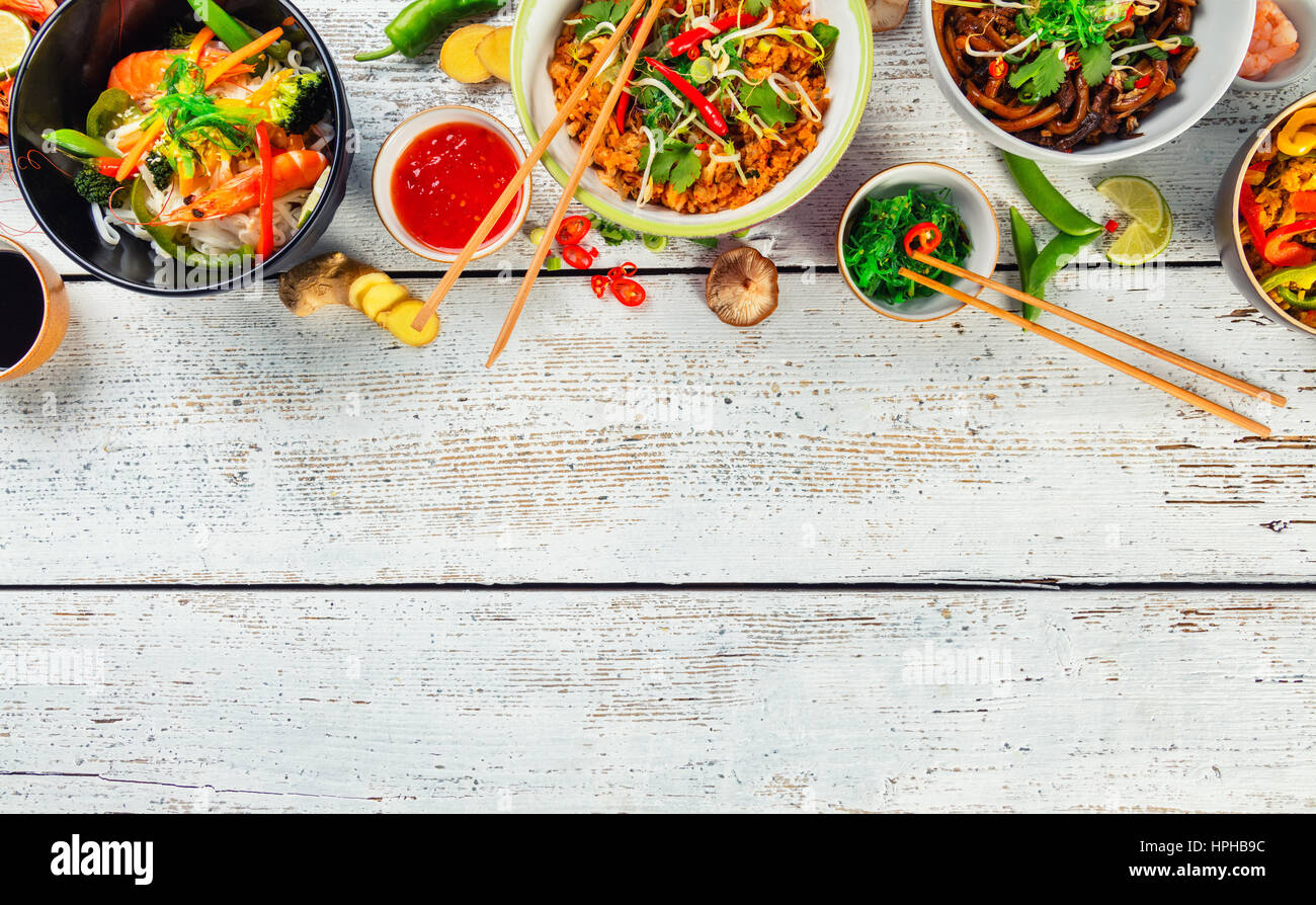 Asian food served on white wooden table, top view, space for text ...