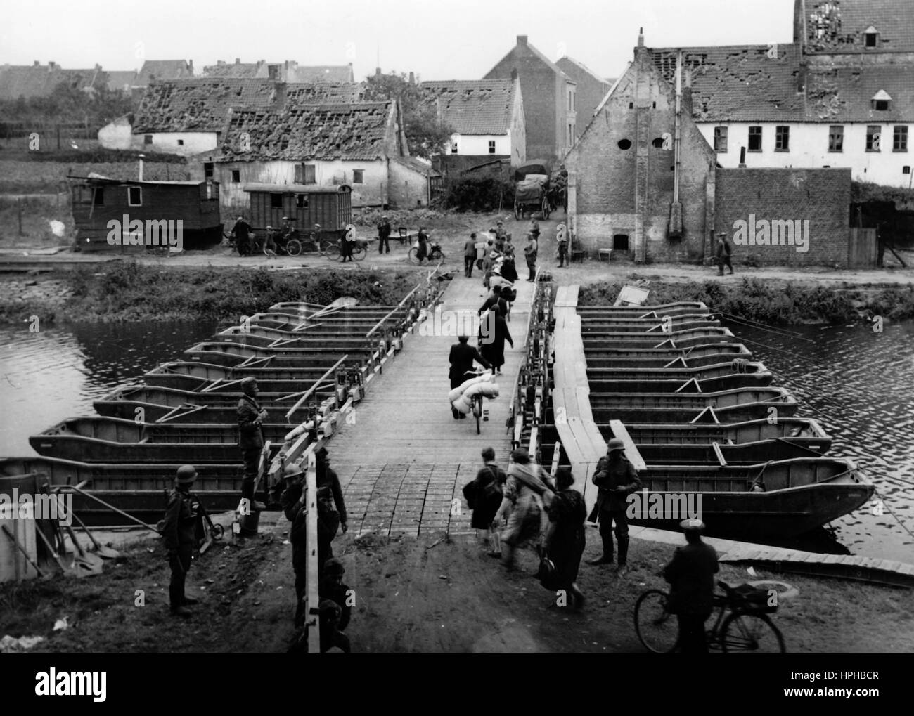 The Nazi propaganda image shows civilians crossing a river on a pontoon ...