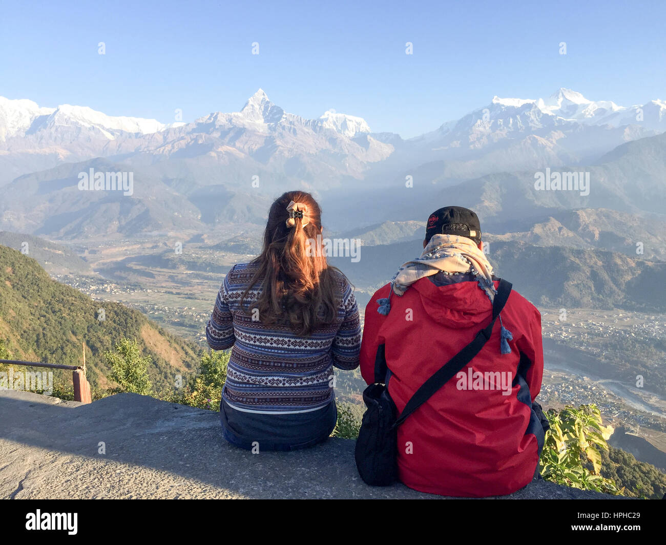 Tourist facing the Annapurna Mountain Range after sunrise at Sarangkot ...