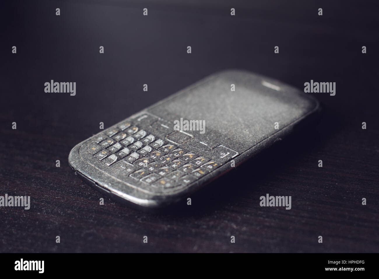 side view close up of old black smartphone mobile with qwerty keyboard ...