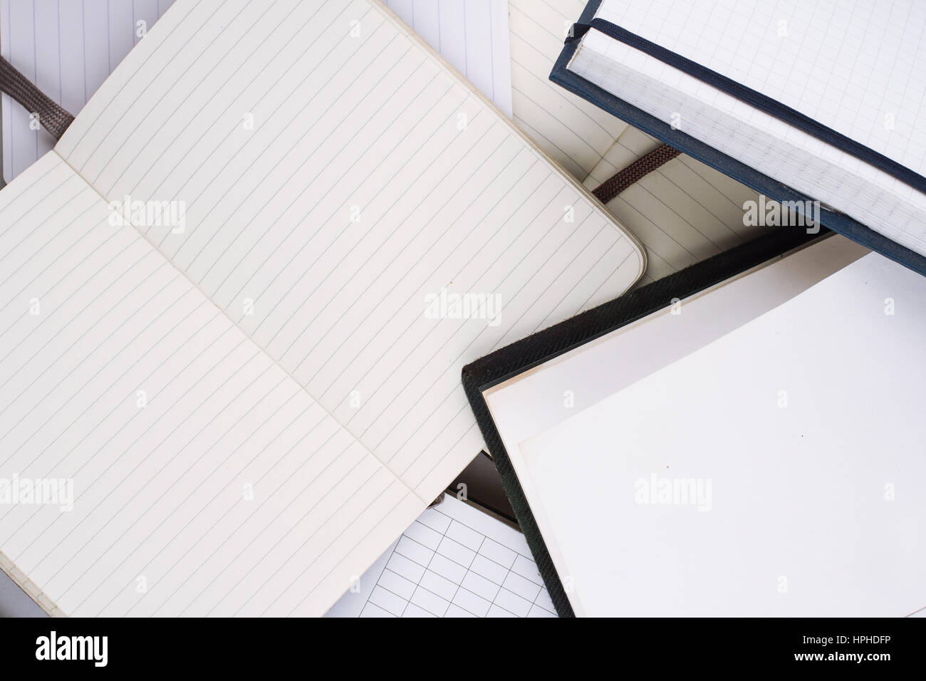 horizontal top view of many open notebooks in different shapes and ...