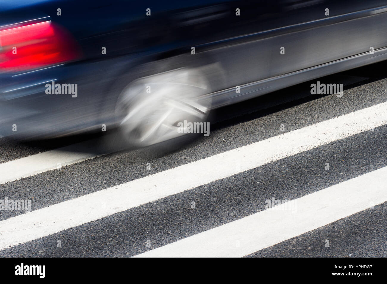 Horizontal side view of a black car with motion blur speeding over a ...