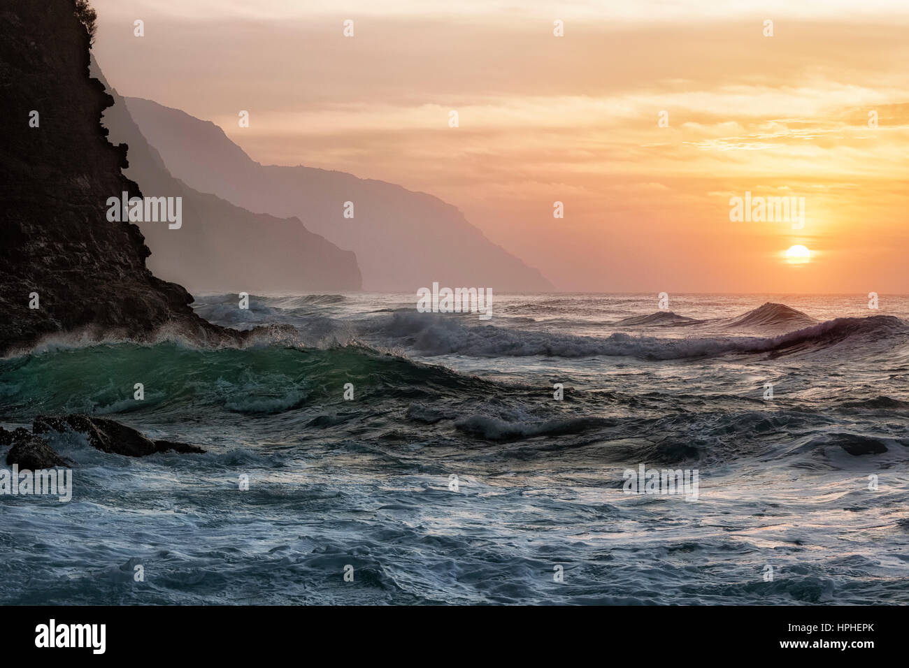 The setting sun with powerful winter surf conditions near Kee Beach ...