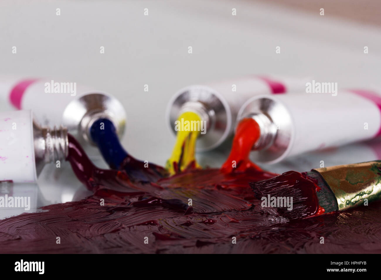 Open tubes of paint mixing with dirty brush Stock Photo - Alamy