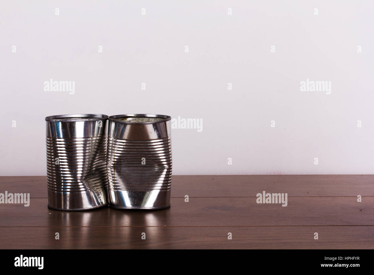 Battered tin cans on a rustic wooden background Stock Photo - Alamy