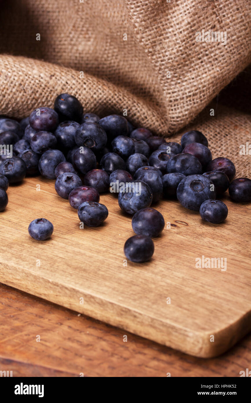 Blueberries spilt over a rustic wooden background Stock Photo - Alamy
