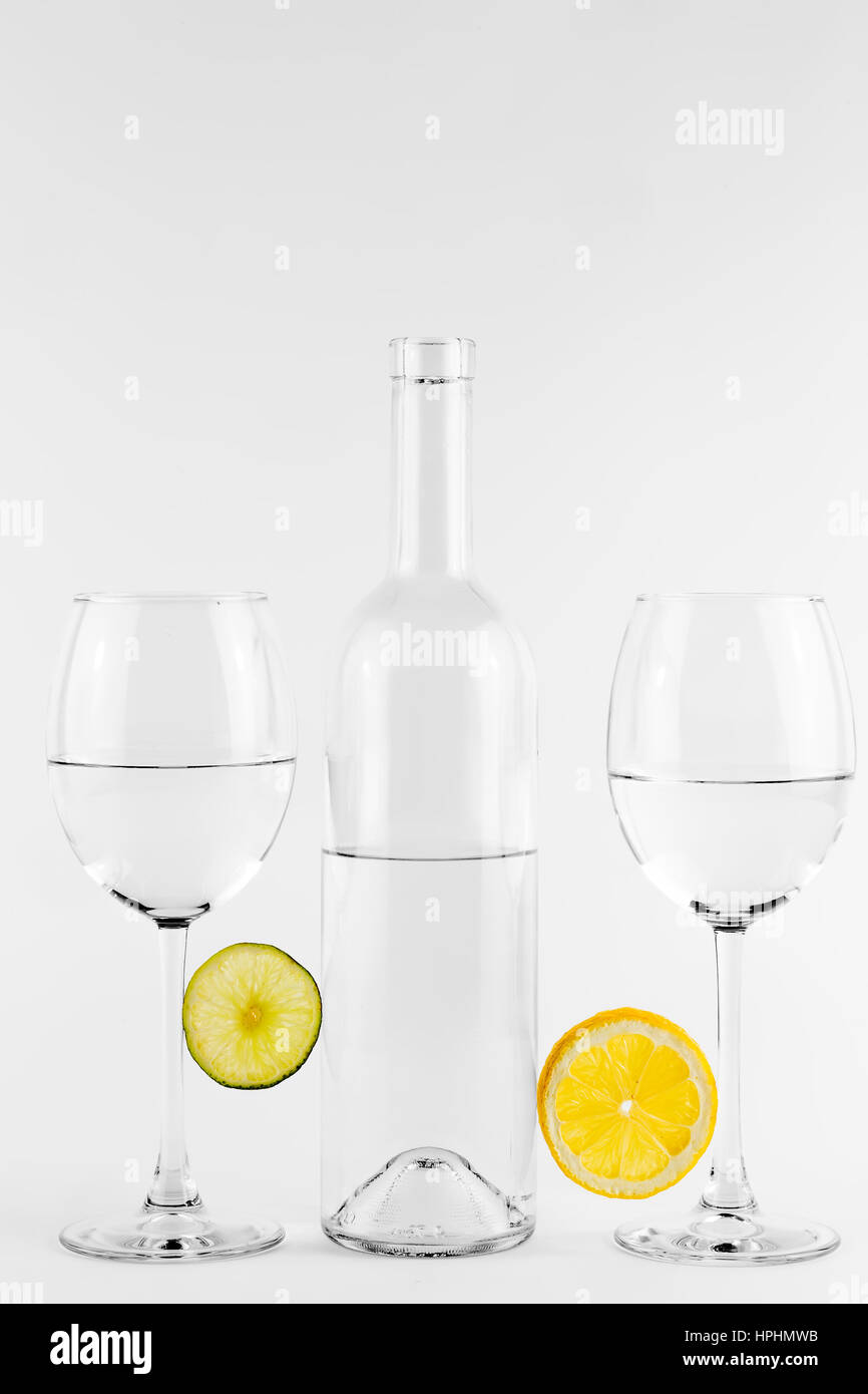 Isolated transparent bottle and glasses with lemon and lime on white ...