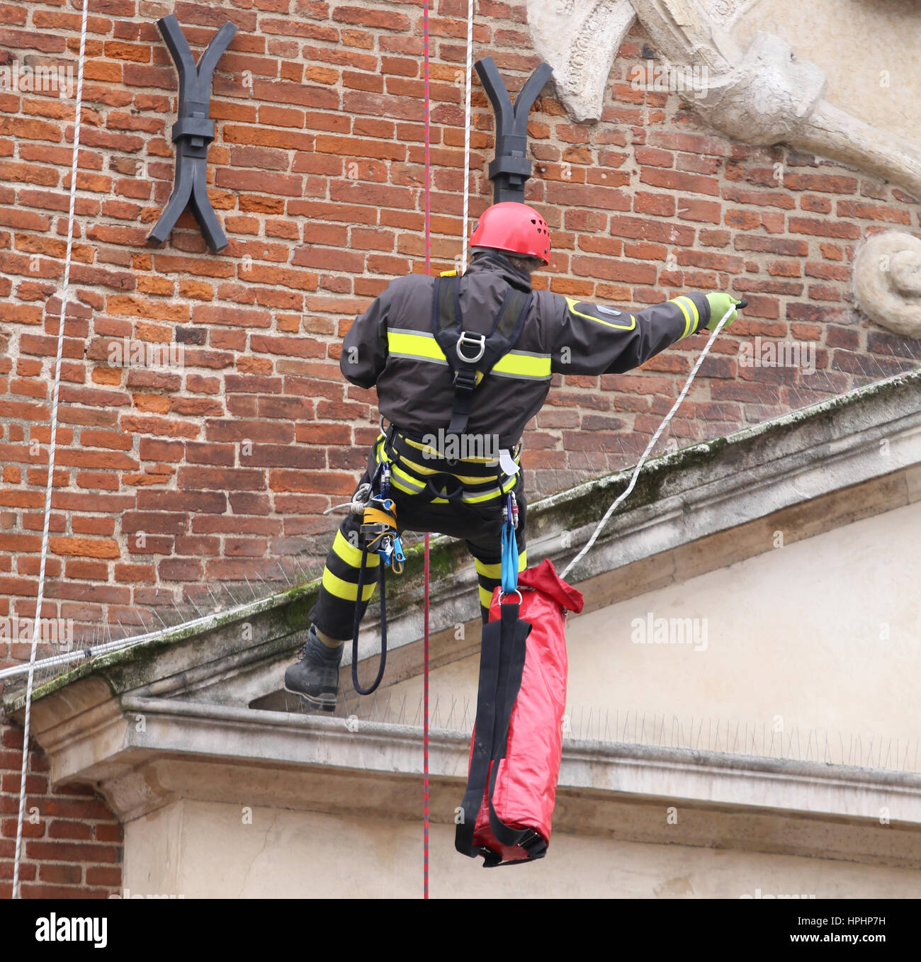 brave firefighters climbing with ropes and climbing equipment on an old ...