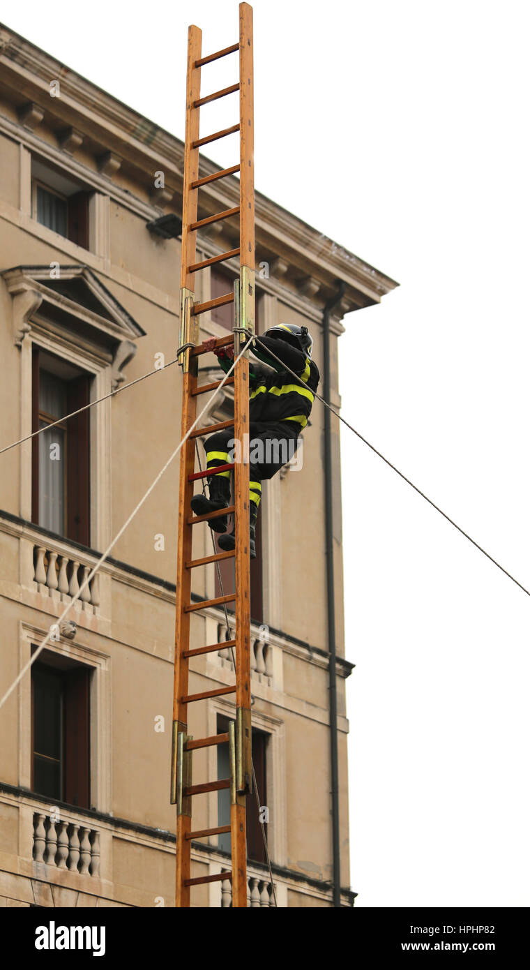fearless firefighter over a high wooden staircase during a rescue ...