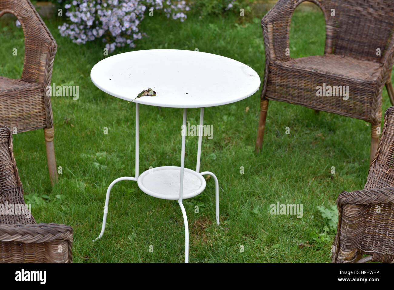 Rattan chairs and white table in a garden. Smoking area Stock Photo - Alamy
